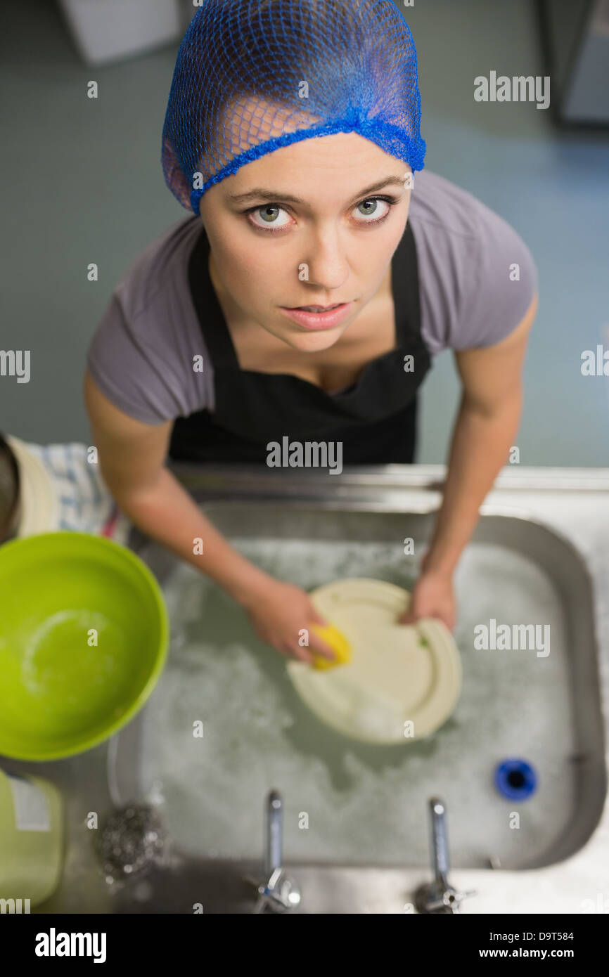 Woman looking up from doing the washing up Stock Photo - Alamy