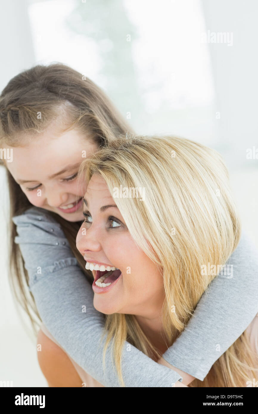 Laughing mother giving daughter a piggy back Stock Photo - Alamy