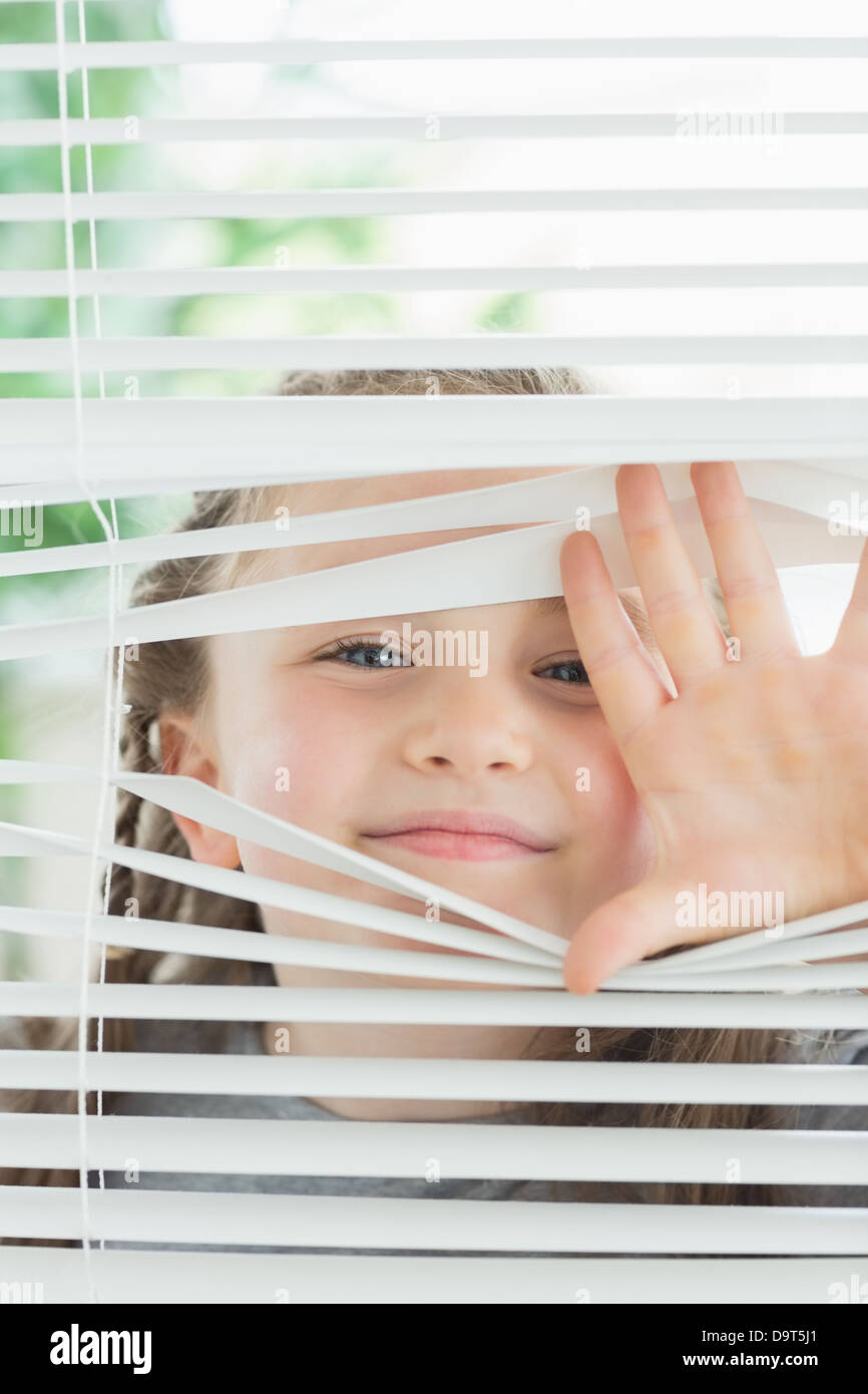 Happy child peeking through blinds Stock Photo - Alamy
