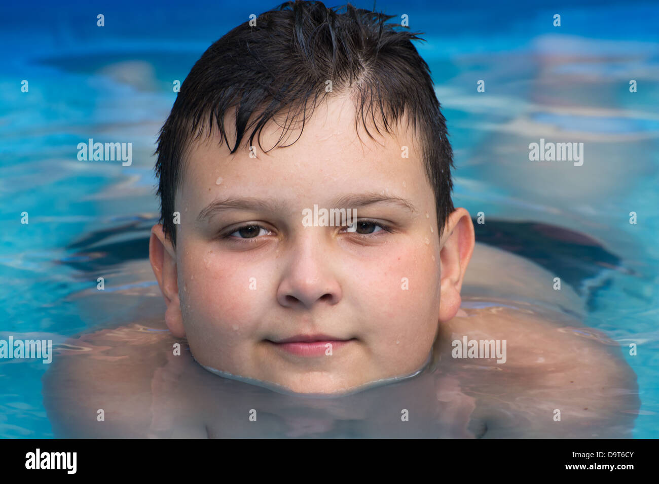 Young boy lying in swimming pool Stock Photo - Alamy