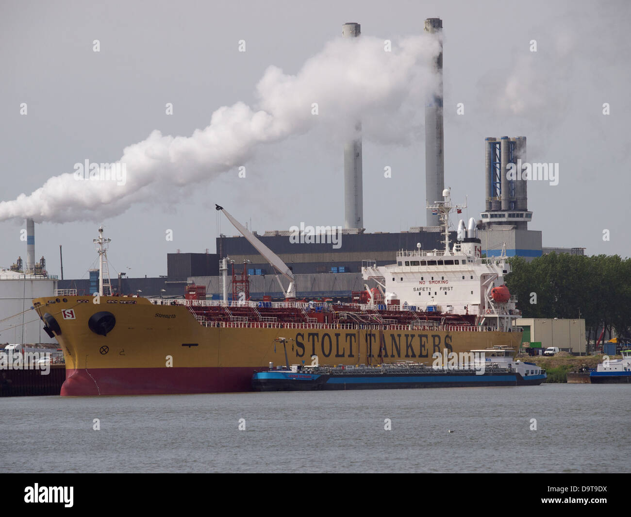 Large tanker ship in the port of Rotterdam with big power station in ...