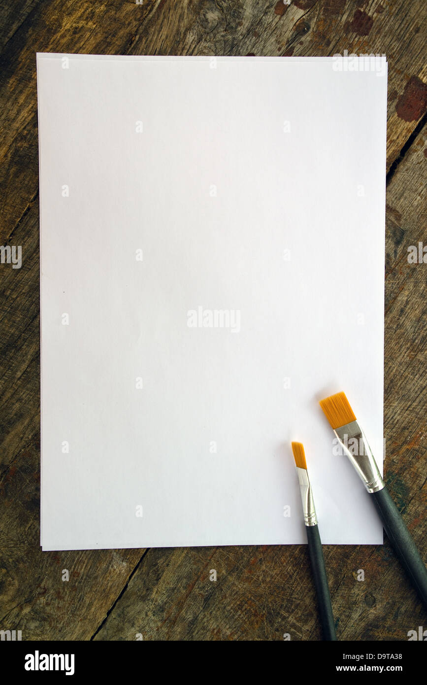Paint brushes and blank white paper on old wood background Stock Photo ...