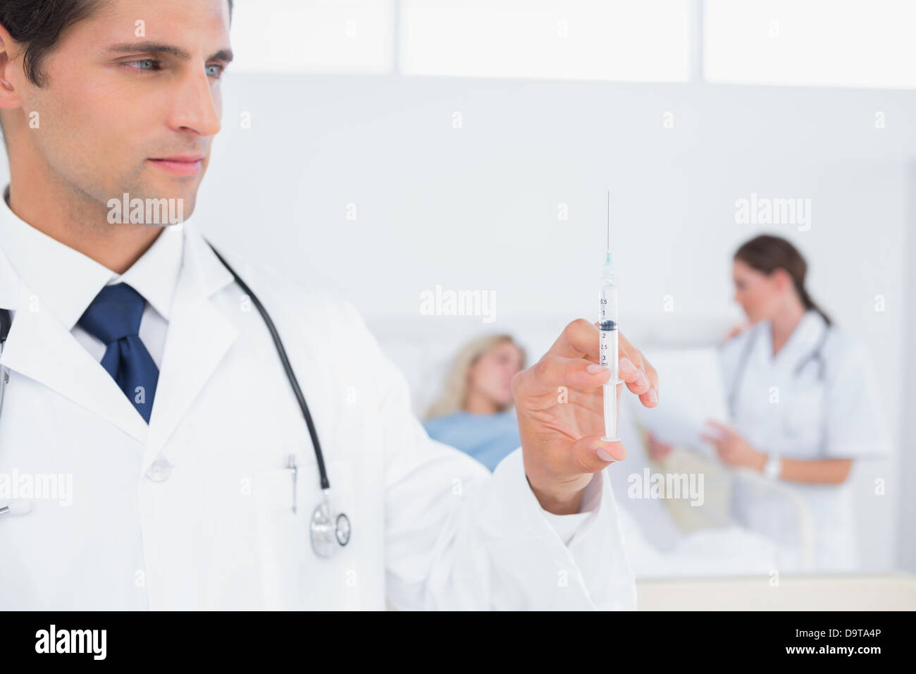 Handsome doctor holding syringe Stock Photo - Alamy