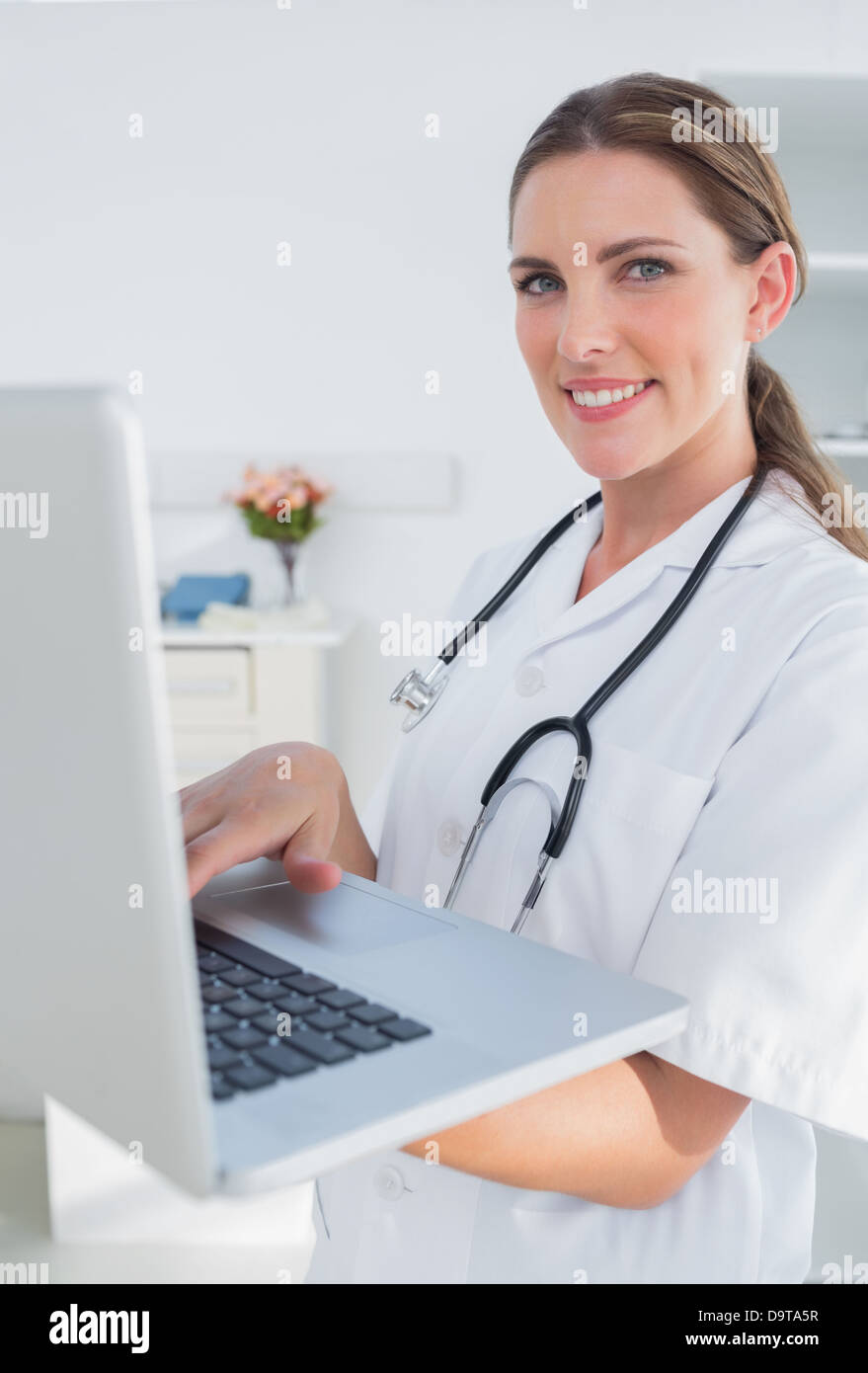 Smiling woman doctor using laptop Stock Photo - Alamy