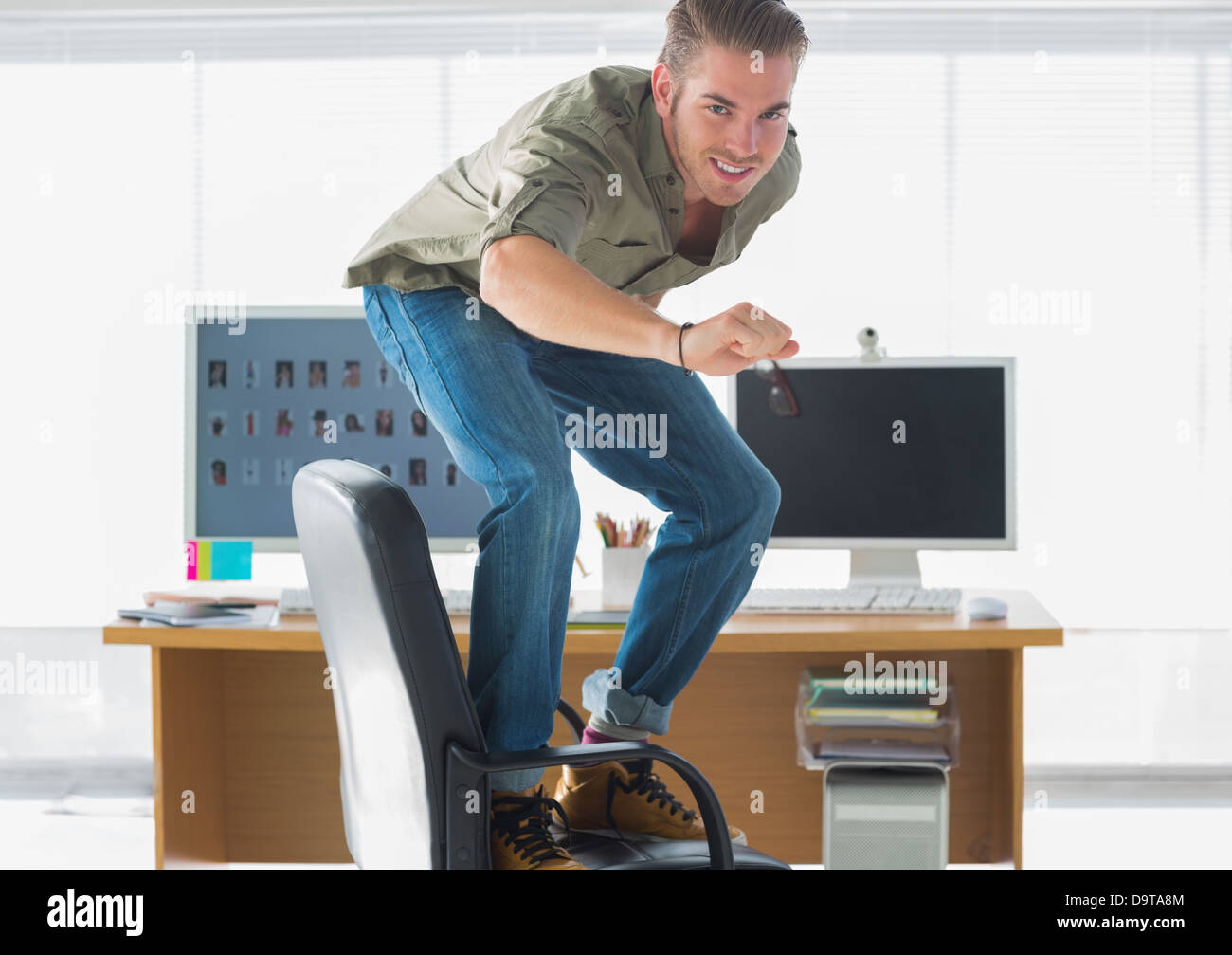 Smiling man surfing his office chair Stock Photo - Alamy