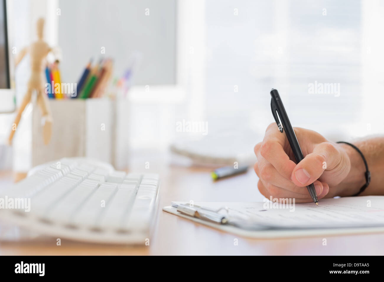 Close up of a hand writing in a modern office Stock Photo - Alamy