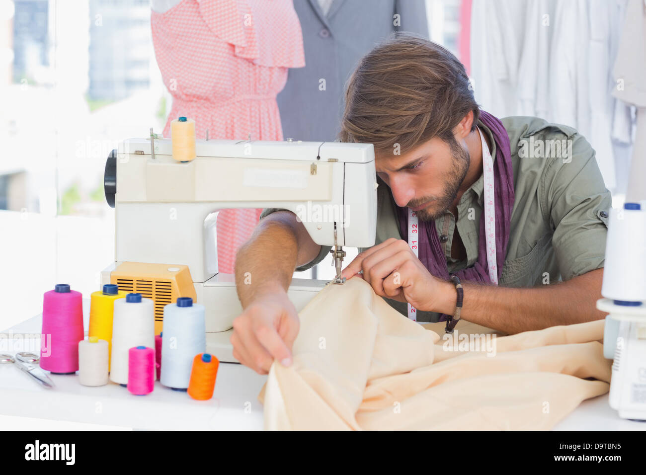 Handsome fashion designer sewing Stock Photo - Alamy