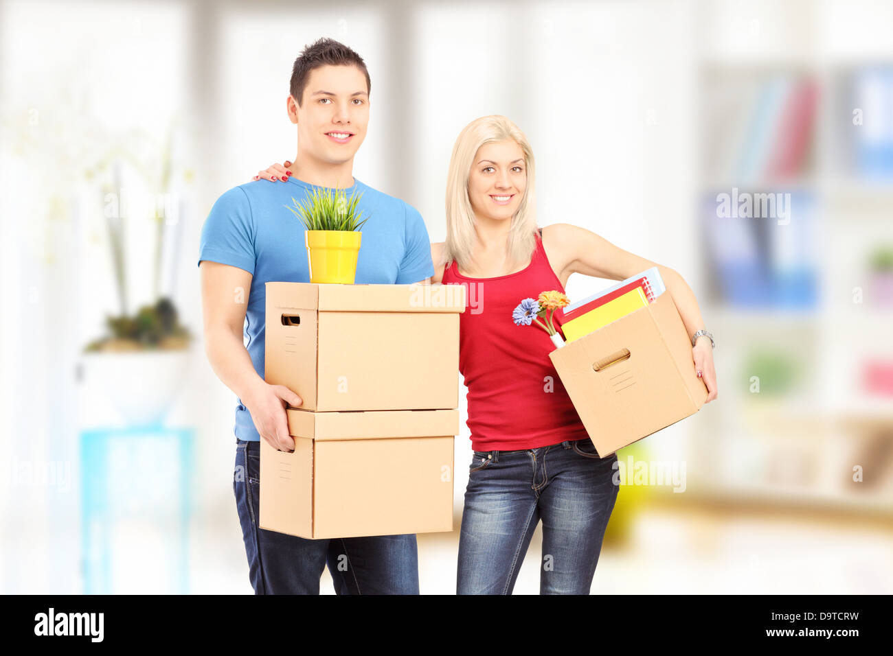 Young couple holding moving boxes and posing at home Stock Photo - Alamy