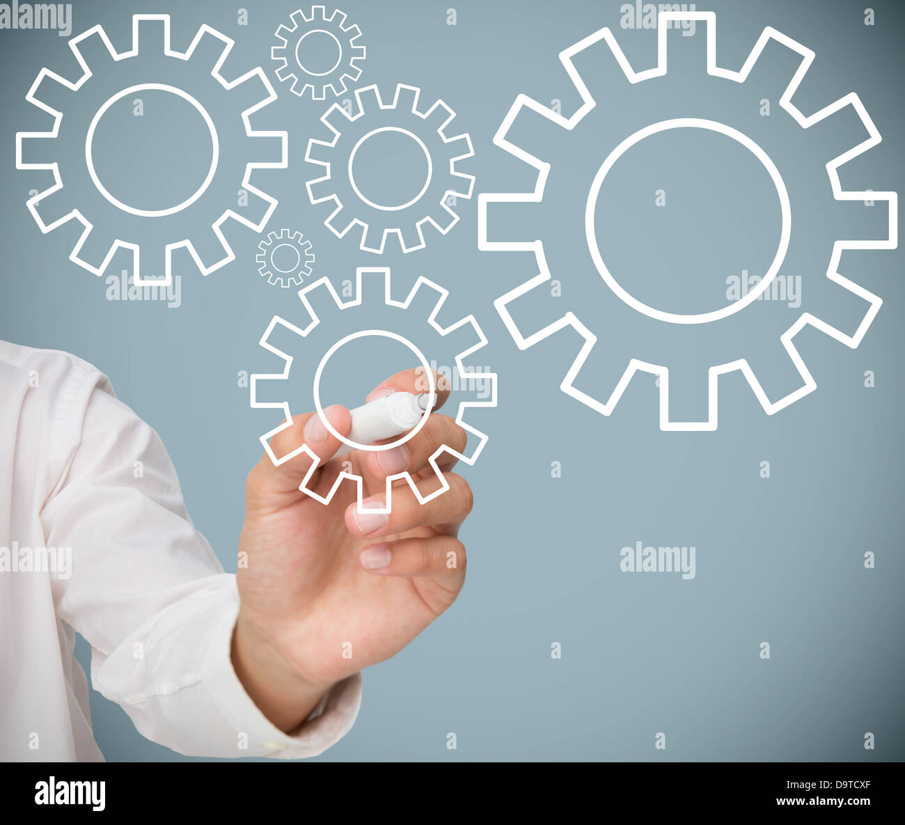 Businessman drawing cogs and wheels Stock Photo - Alamy