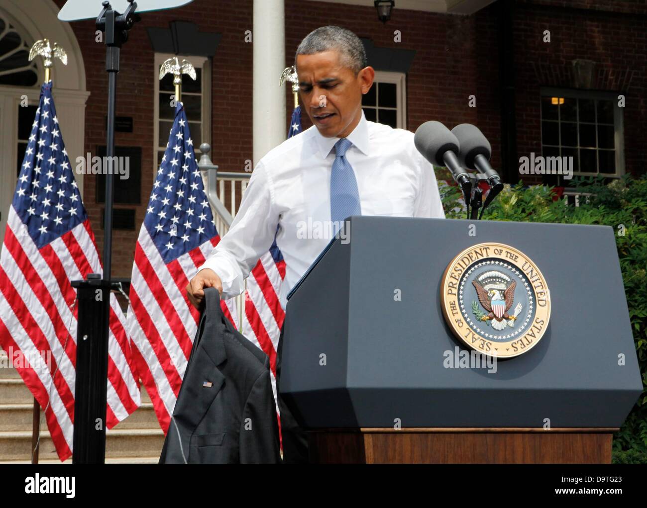 United States President Barack Obama removes his suit coat on a hot day ...