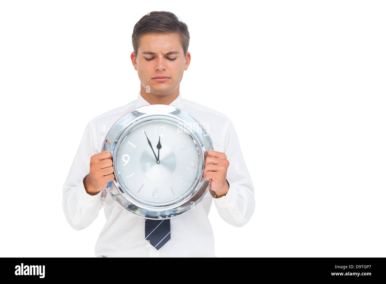Businessman holding and looking at clock Stock Photo - Alamy