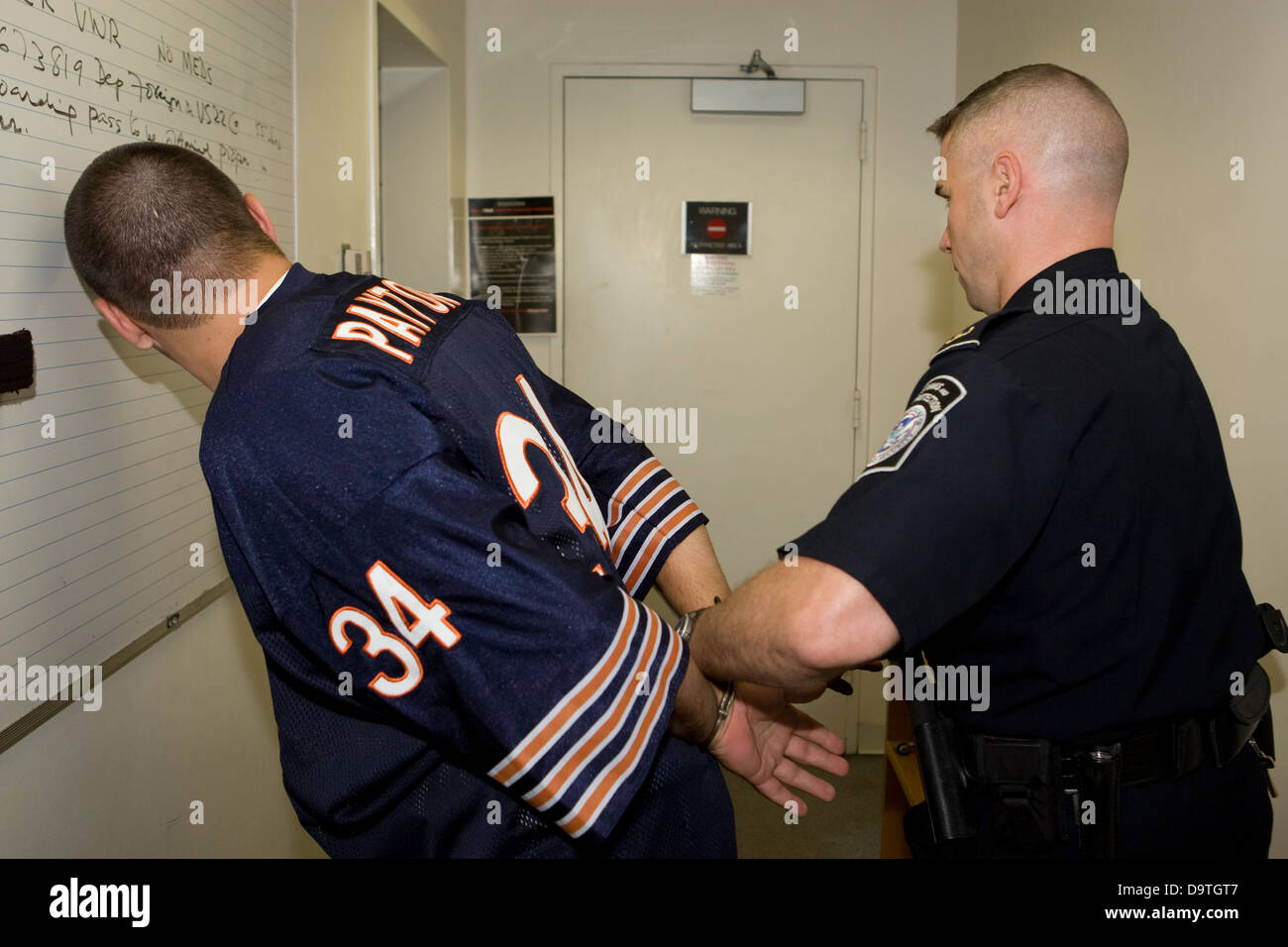 A U.S. Customs and Border Protection officer is shown restraining a ...