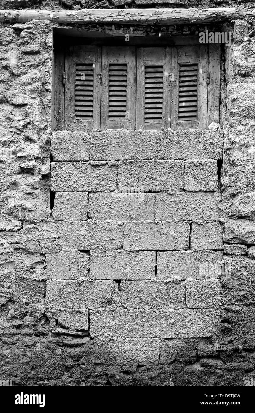 Bricked up window and textured wall abandoned house exterior. Black and ...