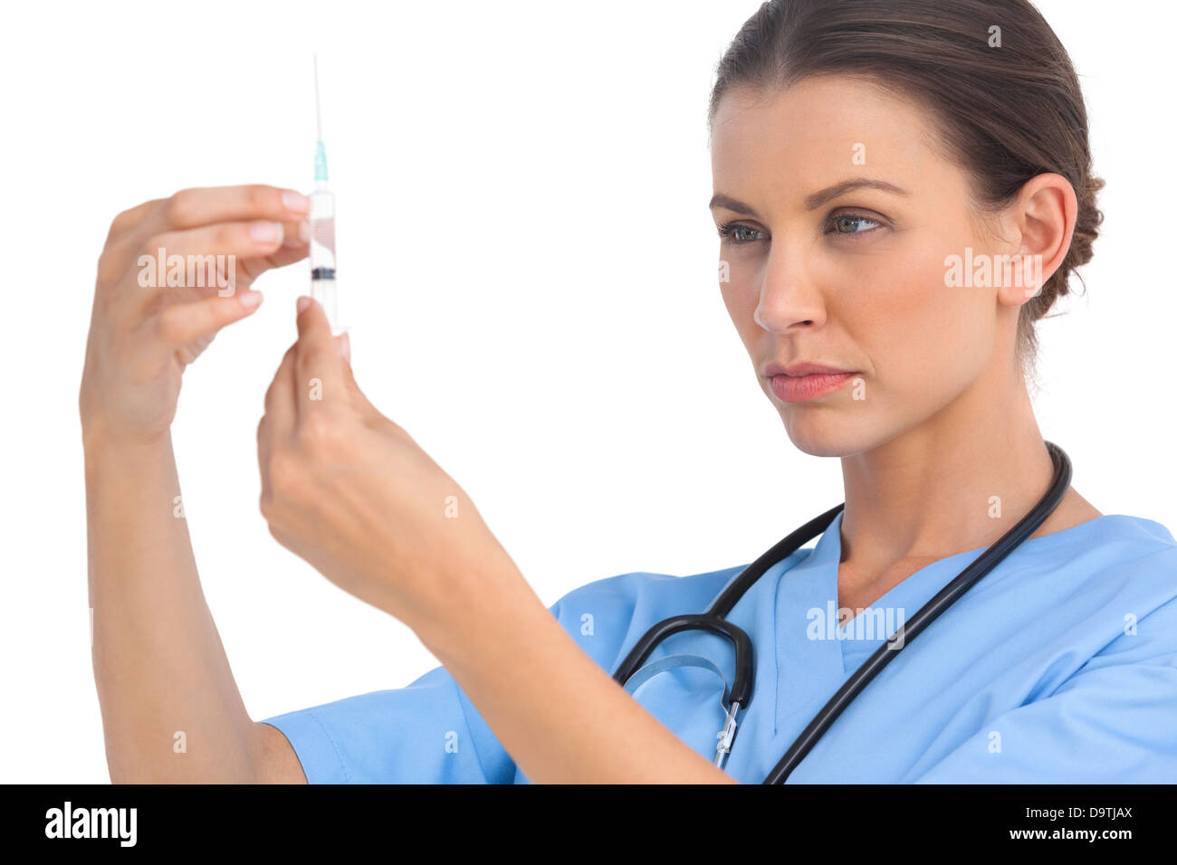 Serious surgeon holding up a needle and checking it Stock Photo - Alamy