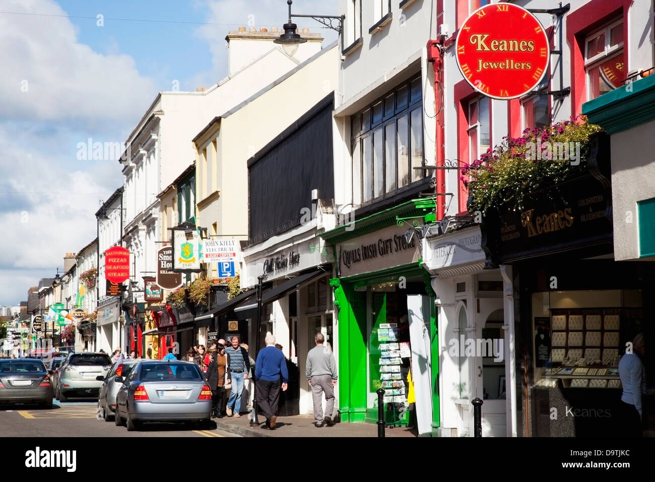 A busy urban street with pedestrians shops and cars;Killarney county ...