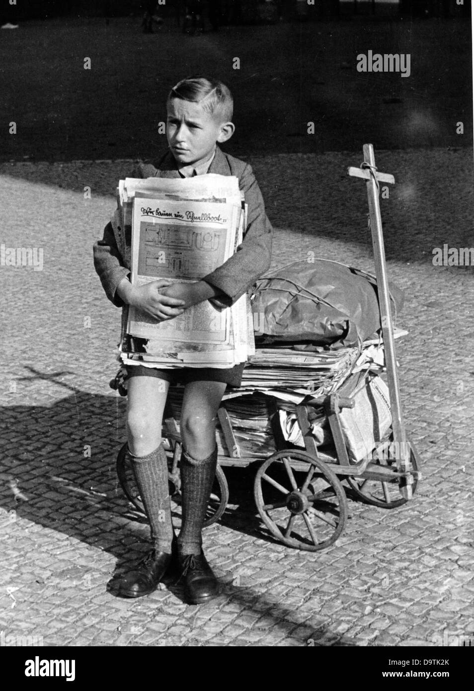 A boy has collected old newspapers and brings them to the collecting ...