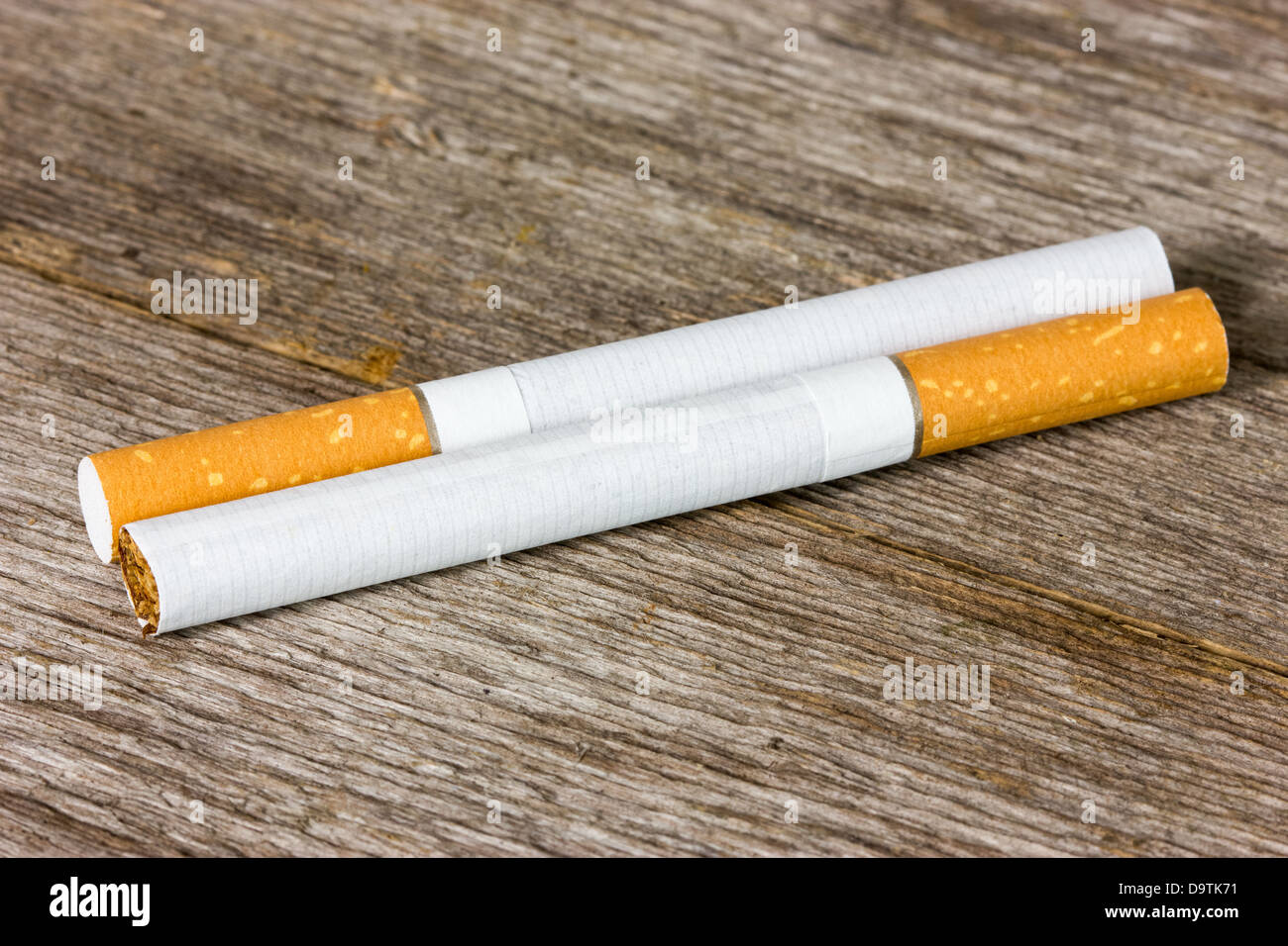 Two cigarettes on the old wooden floor Stock Photo - Alamy