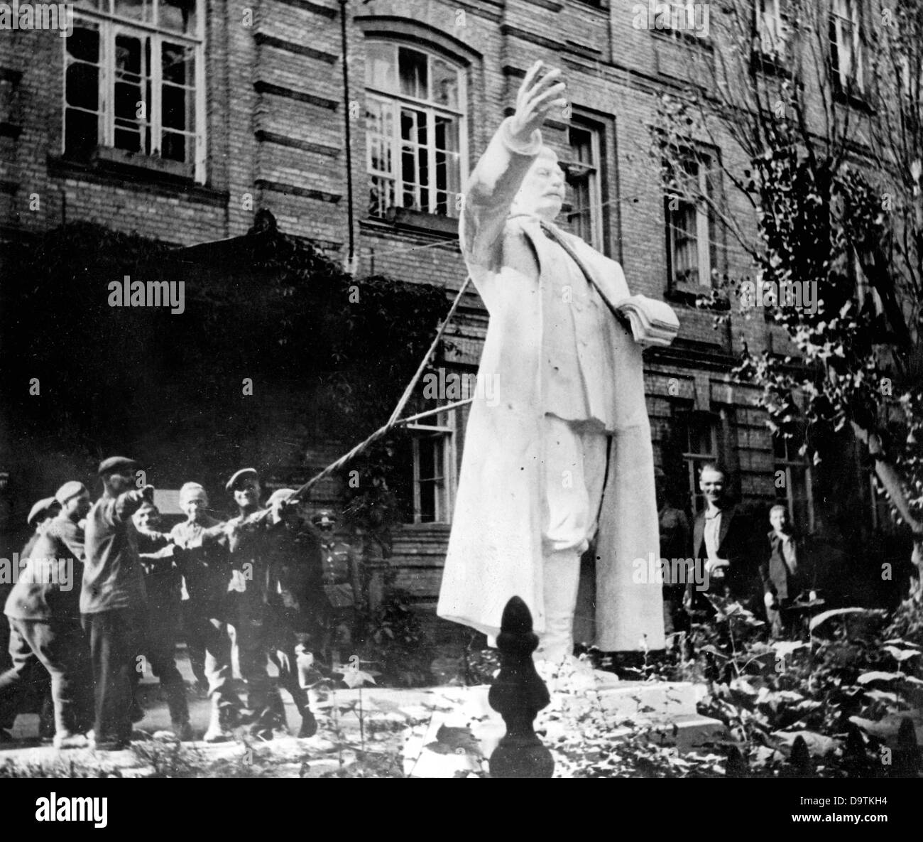 A Stalin monument is torn down under the supervision of a German ...