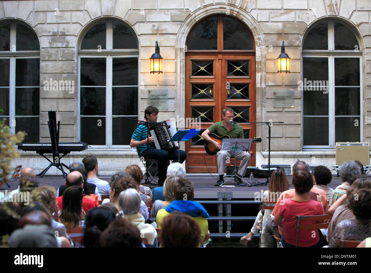 Musicians performing on stage and raws of public during traditional ...