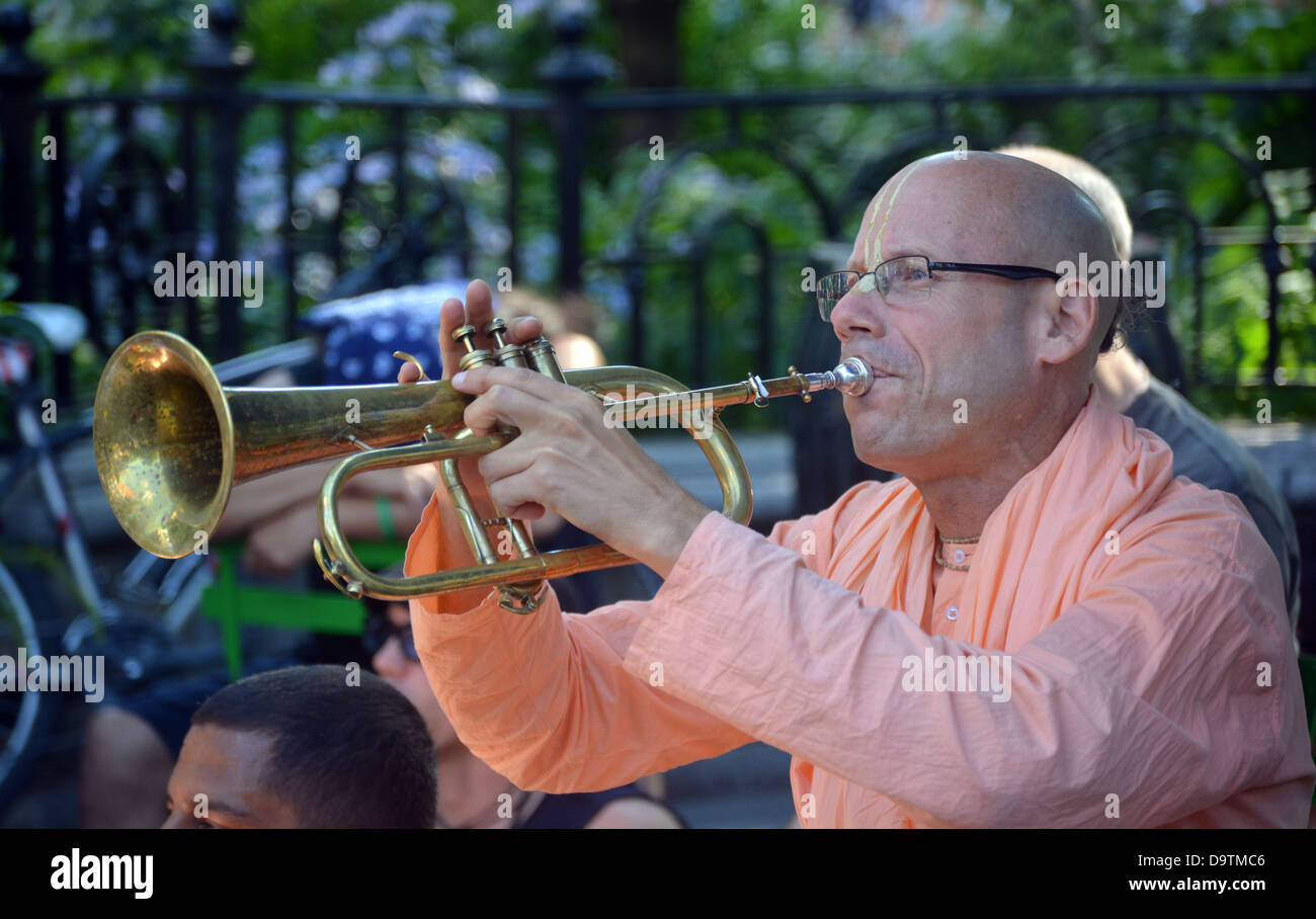 Middle aged bald Hare Krishna street performer playing the flugelhorn ...