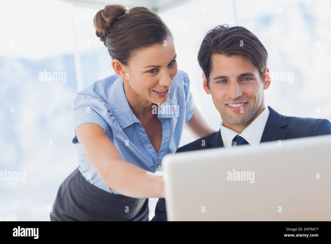 Happy business people looking together at the laptop Stock Photo - Alamy