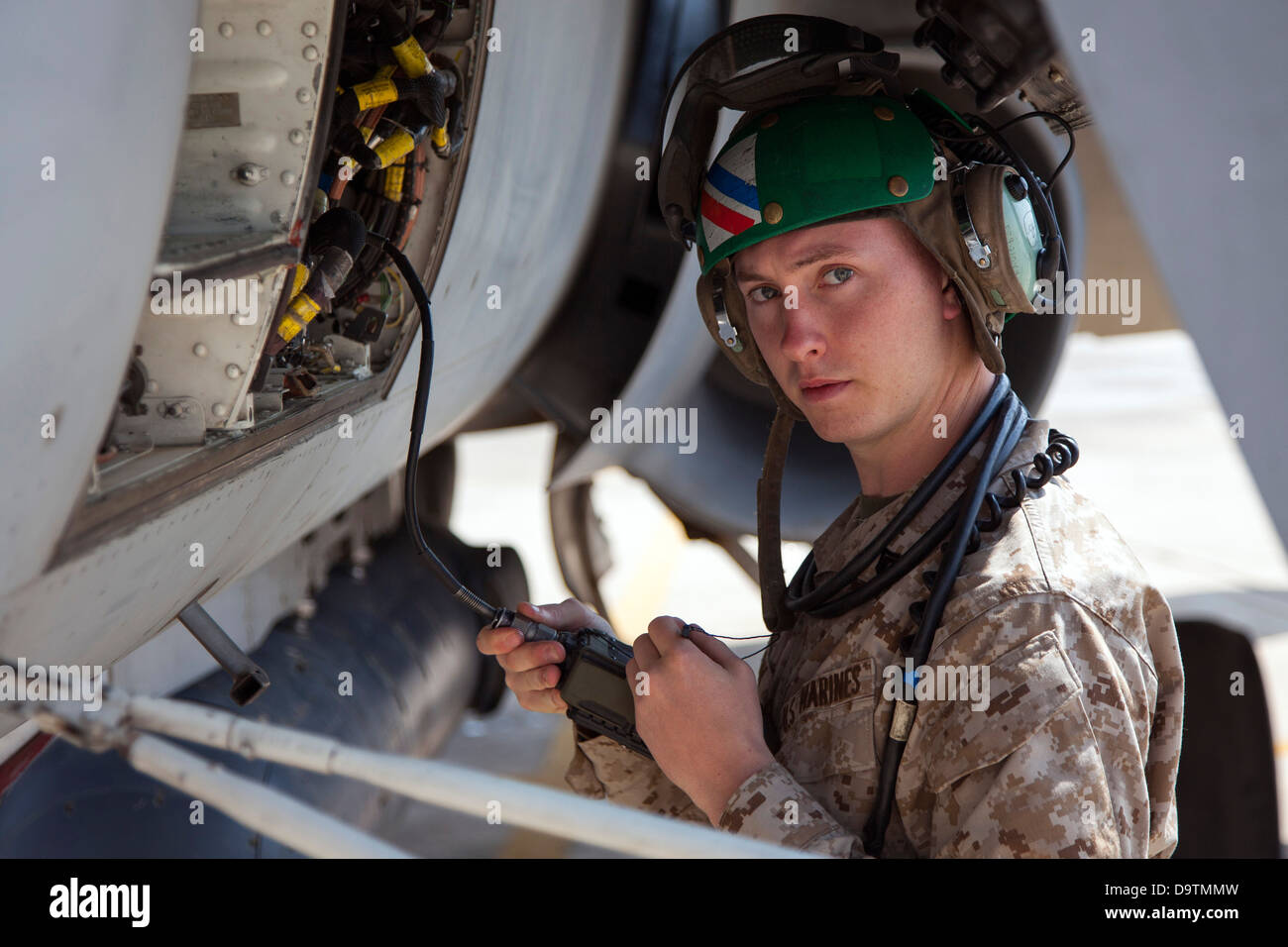 A Marine plane captain from the VMFA-115 squadron checks readings as ...