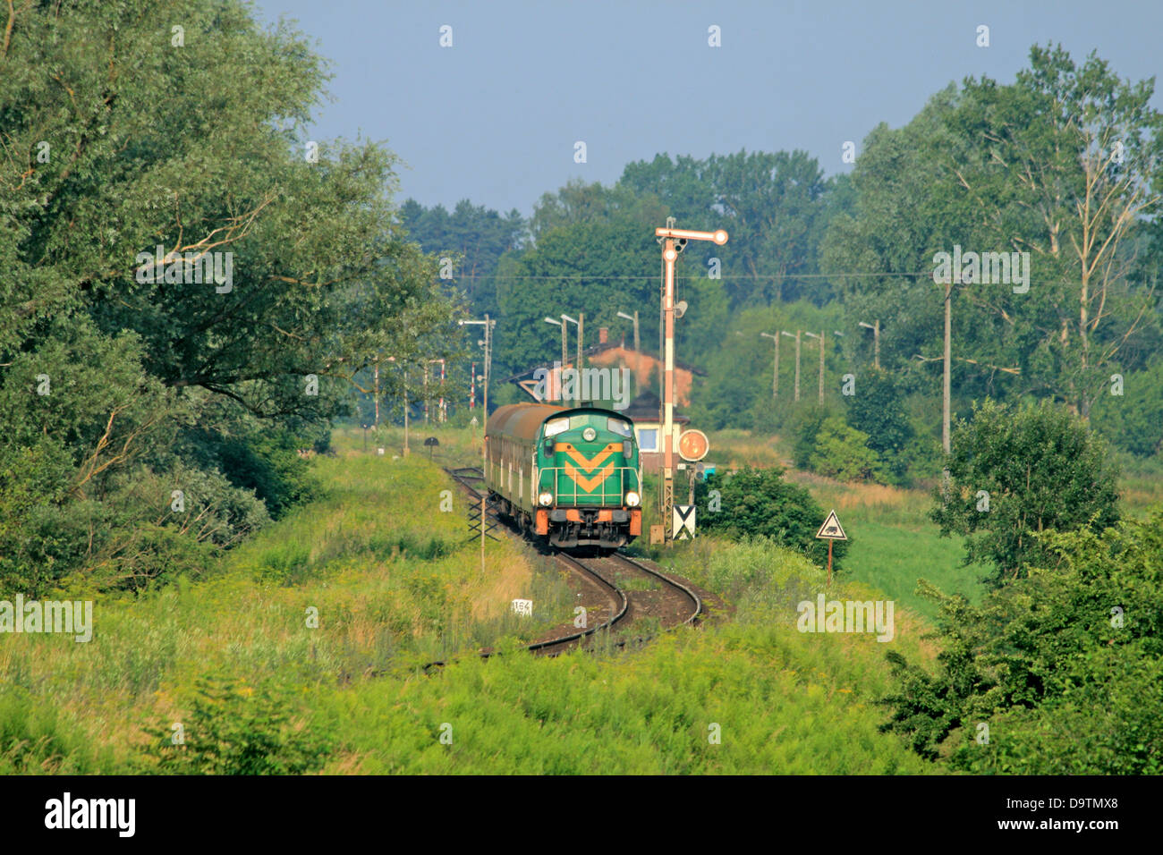 Passenger train starting from the small station Stock Photo - Alamy