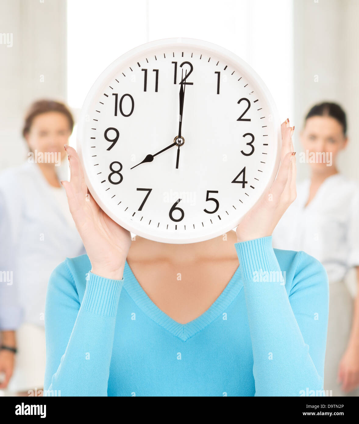 Woman holding clock over face hi-res stock photography and images - Alamy