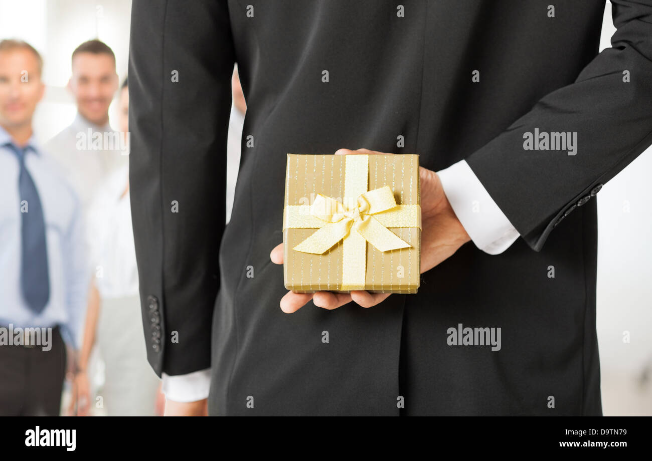 man hands holding gift box in office Stock Photo - Alamy