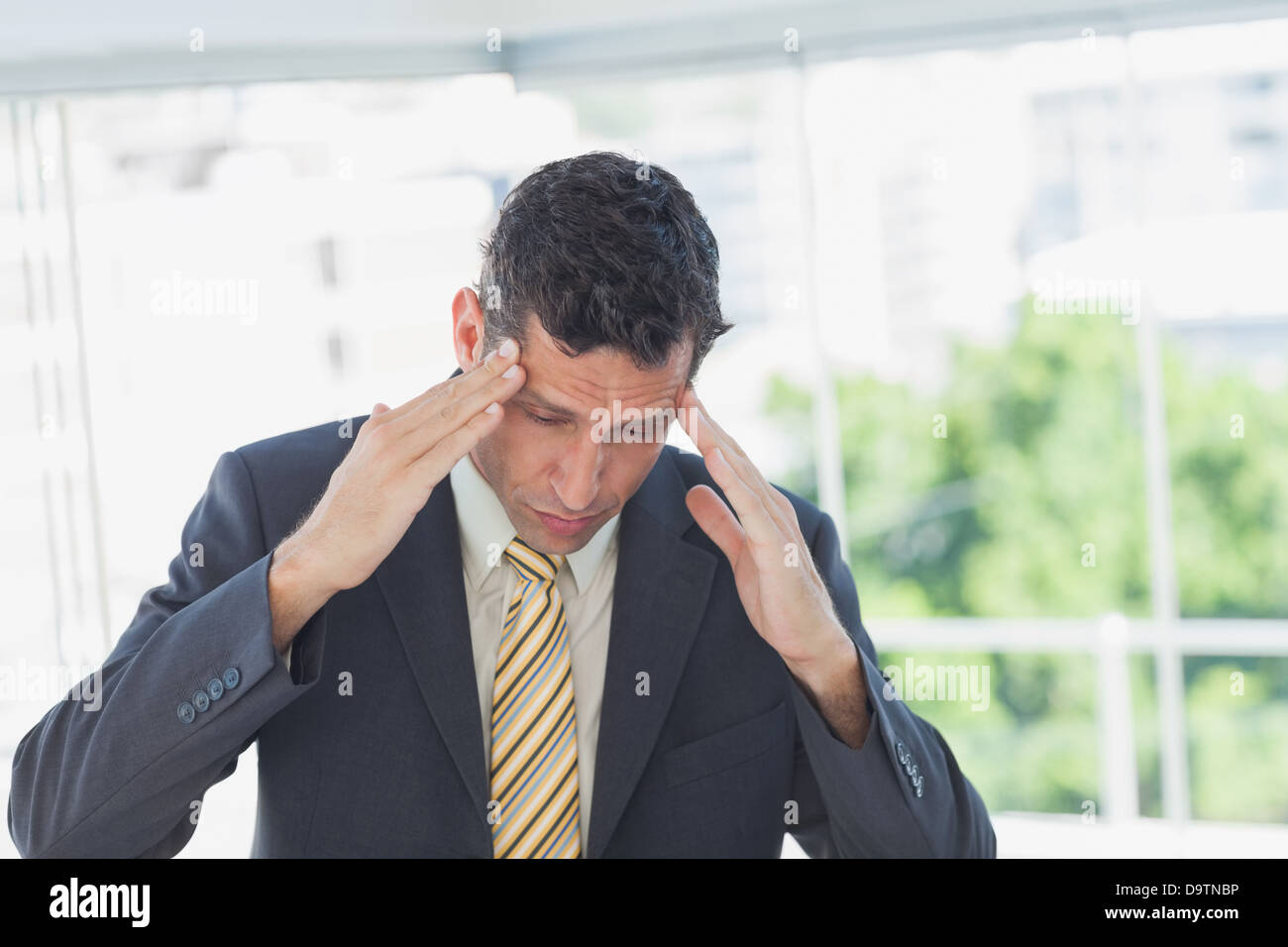 Businessman rubbing his temples Stock Photo - Alamy