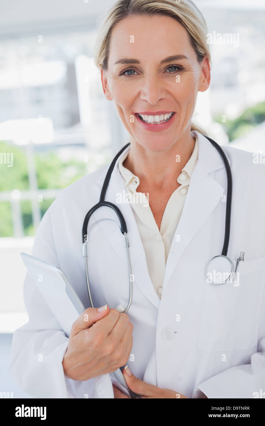 Attractive doctor standing with a clipboard Stock Photo - Alamy