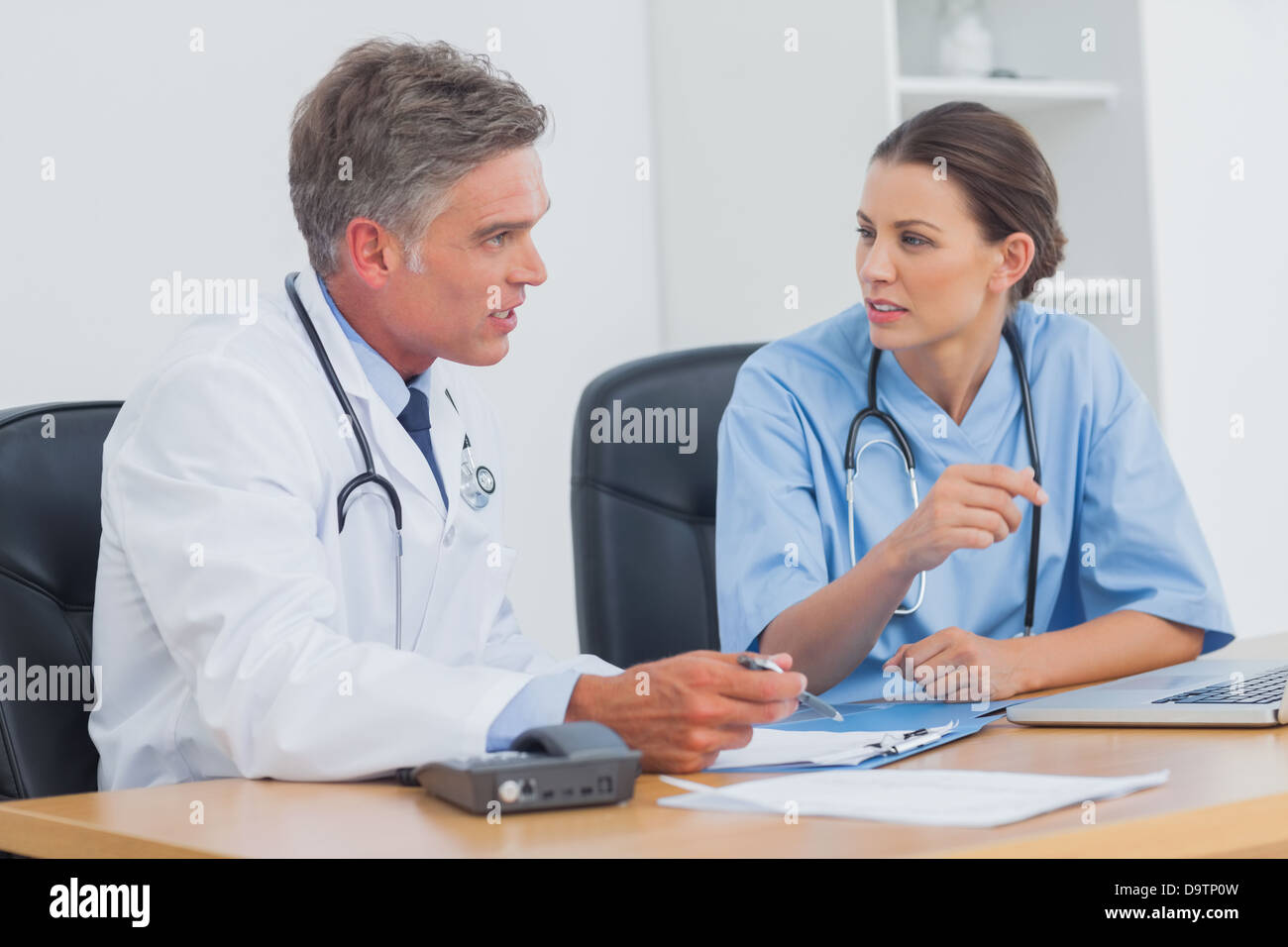Two doctors discussing and working together Stock Photo - Alamy