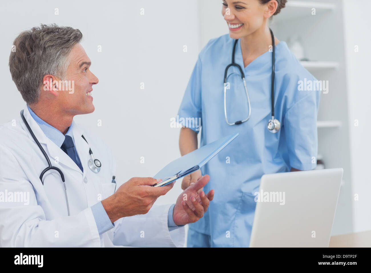 Smiling doctor talking to a colleague Stock Photo - Alamy