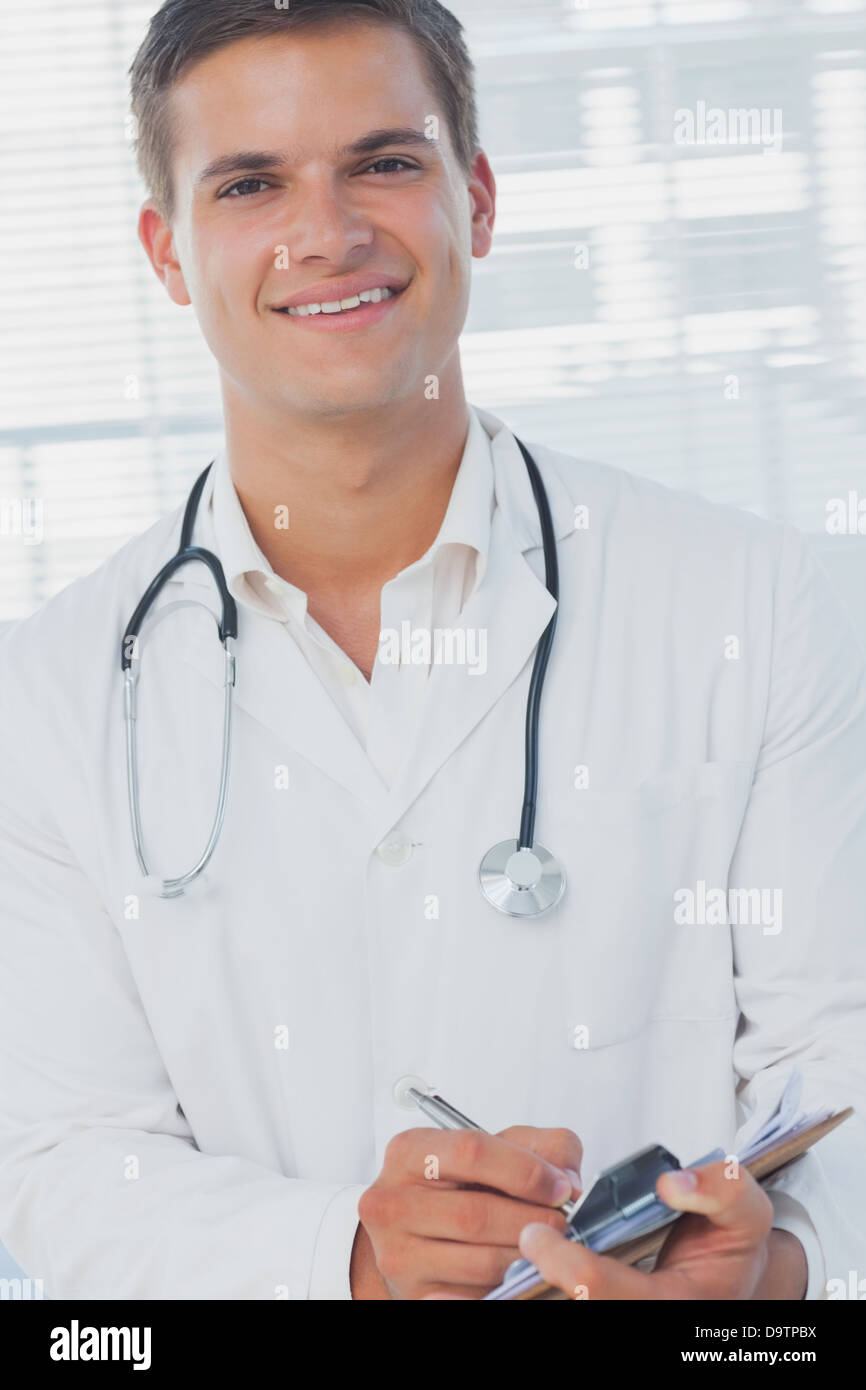 Handsome doctor holding pen Stock Photo - Alamy