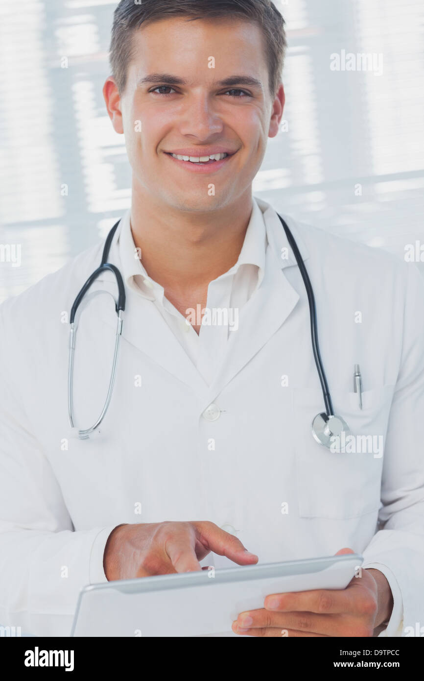 Smiling doctor using tablet Stock Photo - Alamy