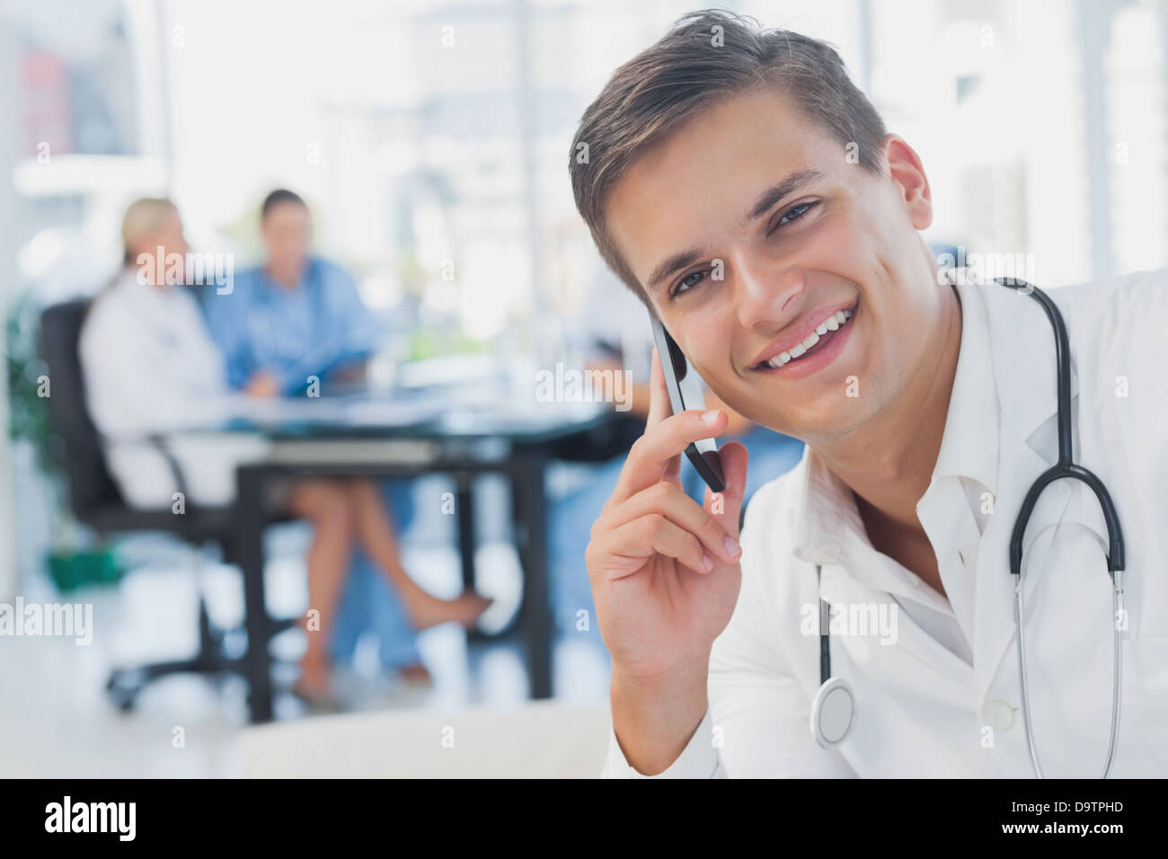 Smiling doctor calling Stock Photo - Alamy