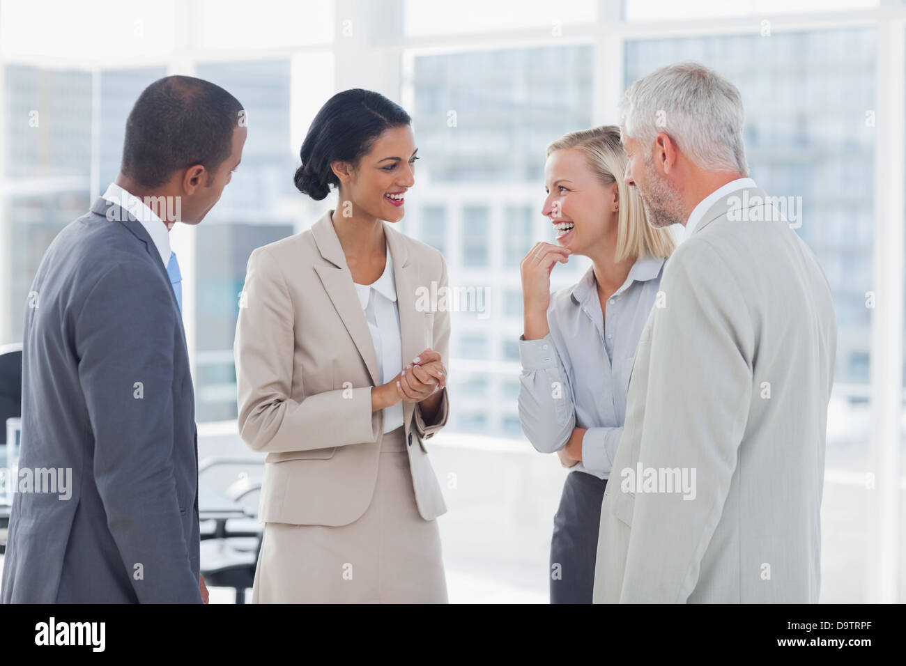Happy business team chatting and laughing Stock Photo - Alamy