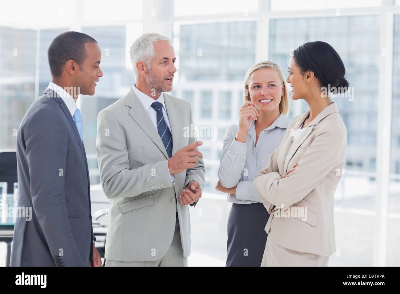 Happy business team talking Stock Photo - Alamy