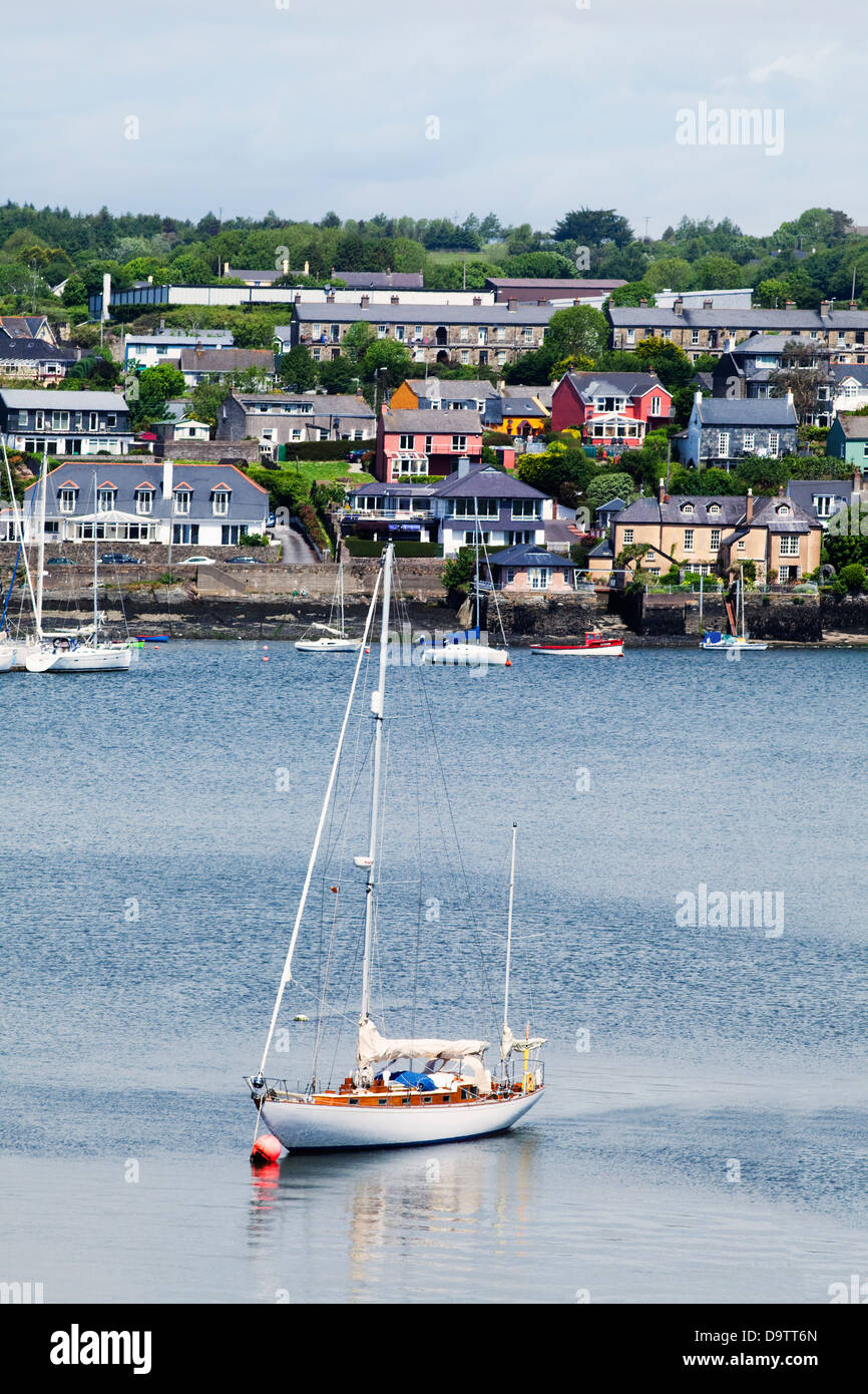 A sailboat in the harbour with houses on the waterfront;Kinsale county ...