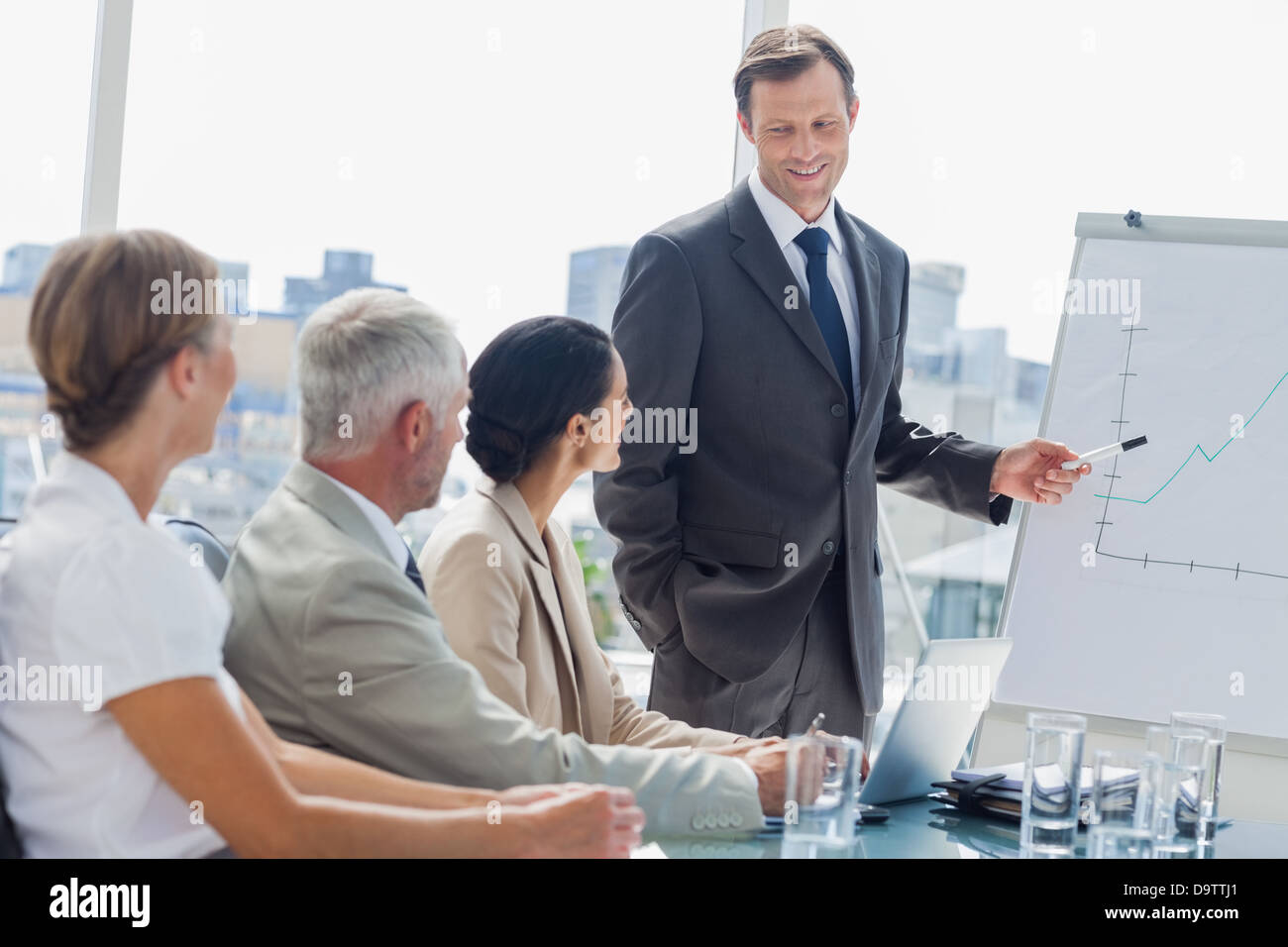 Smiling businessman pointing at whiteboard during a meeting Stock Photo - Alamy
