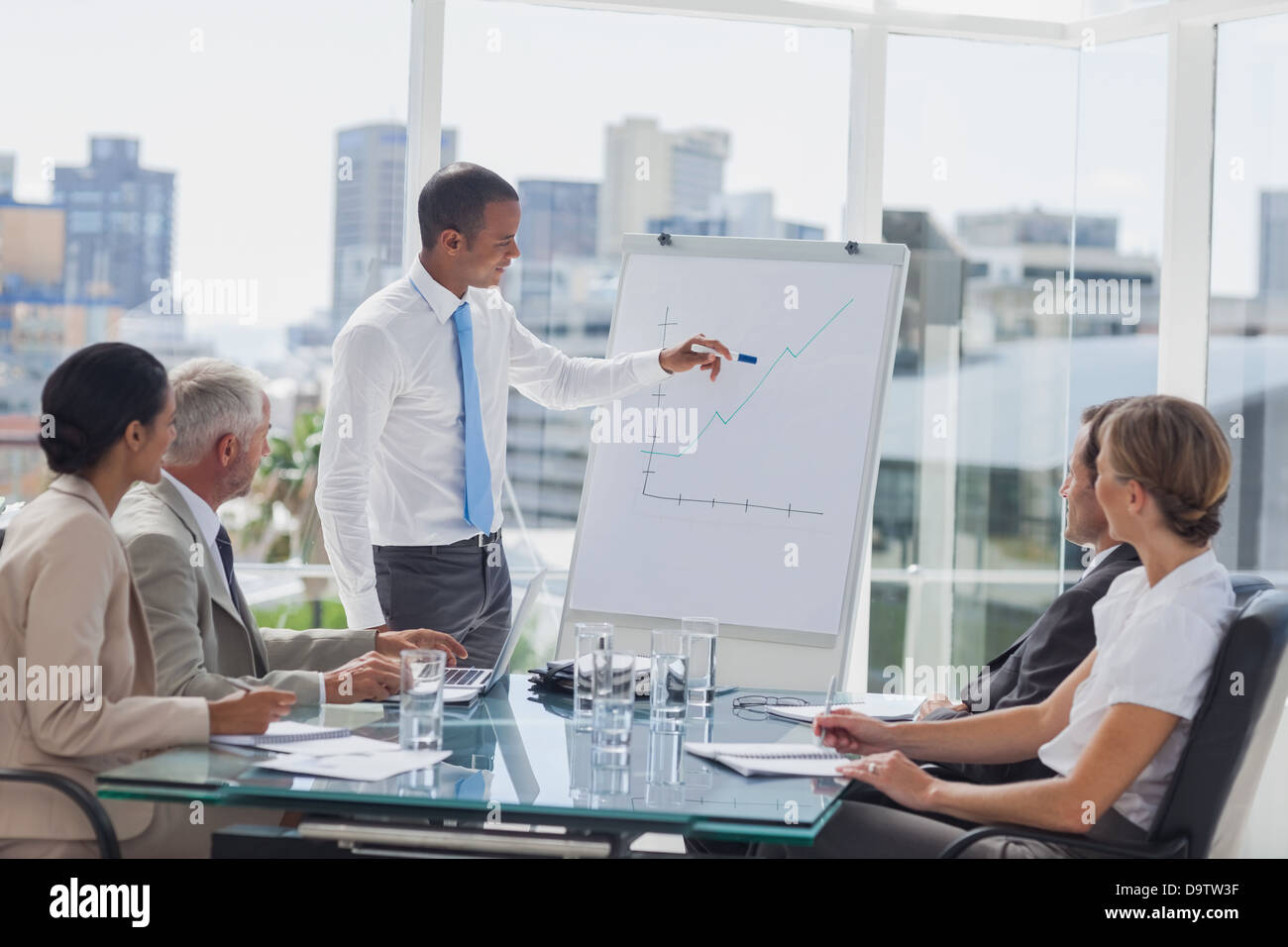 Manager pointing at the peak of a chart during a meeting Stock Photo ...