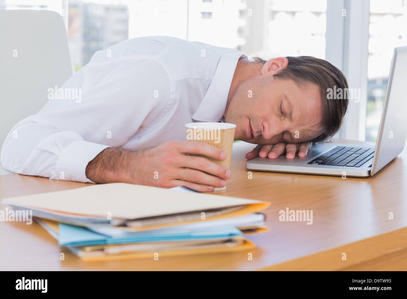 Businessman sleeping on a laptop Stock Photo - Alamy
