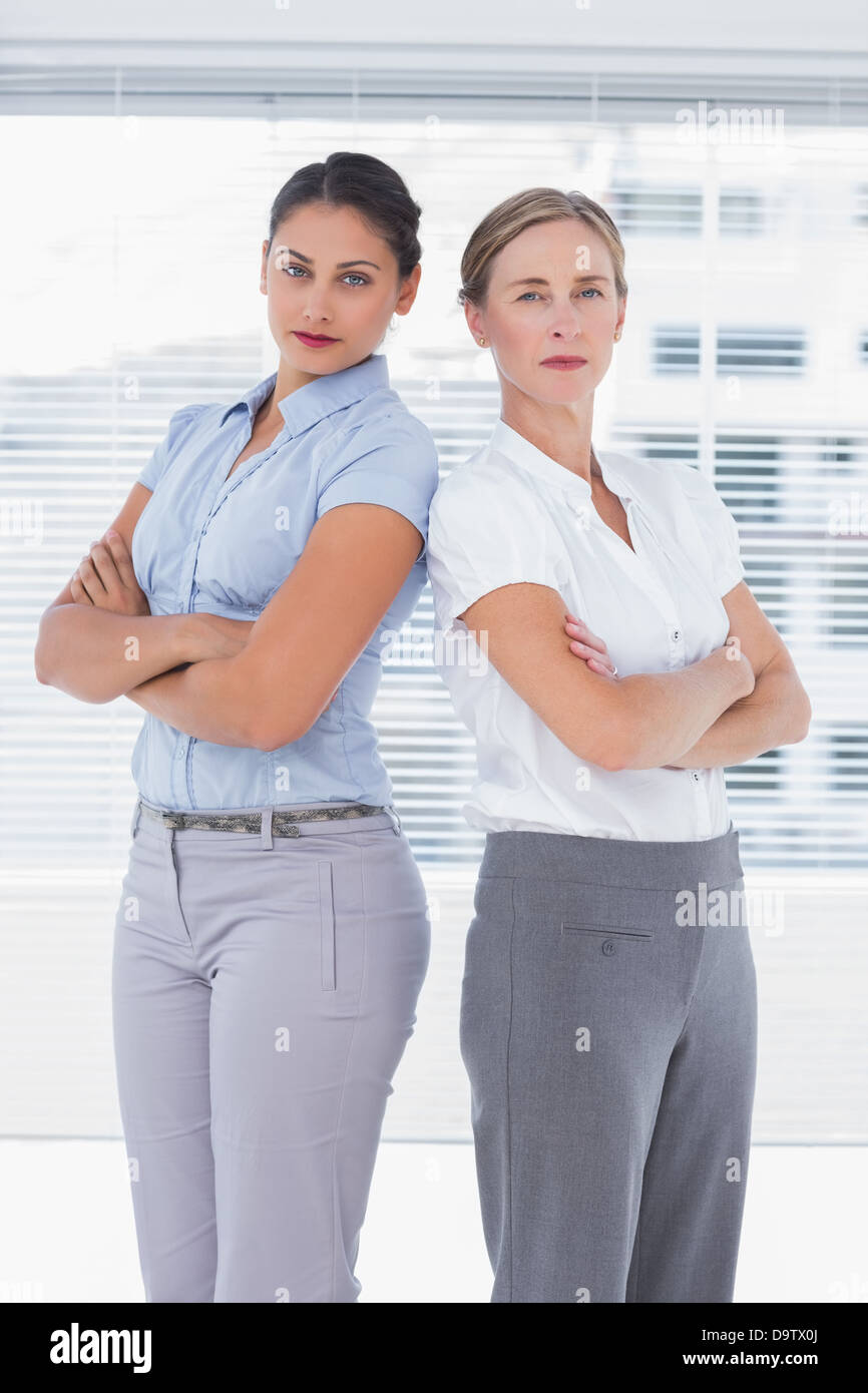 Serious businesswomen standing back to back Stock Photo - Alamy