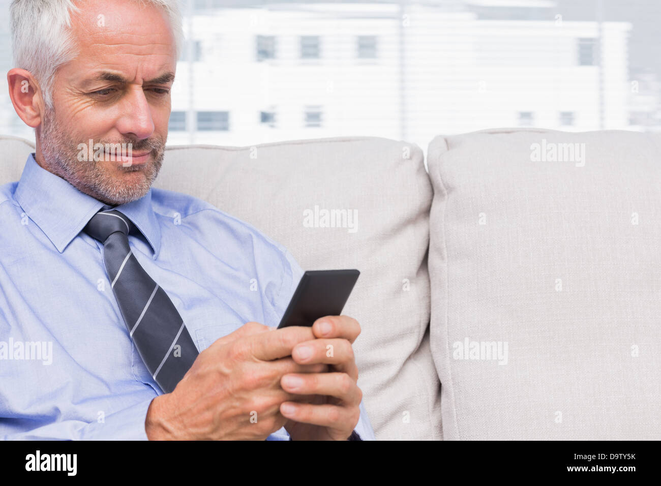 Cheerful businessman using smartphone Stock Photo - Alamy