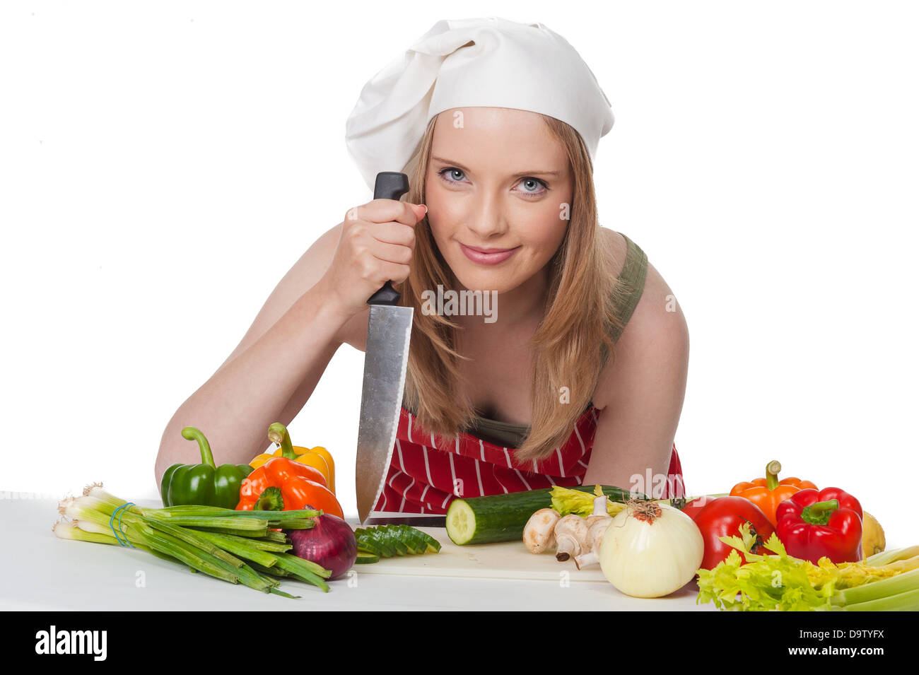 Young lady in chef hat an apron with knife and fruit - humorous concept ...