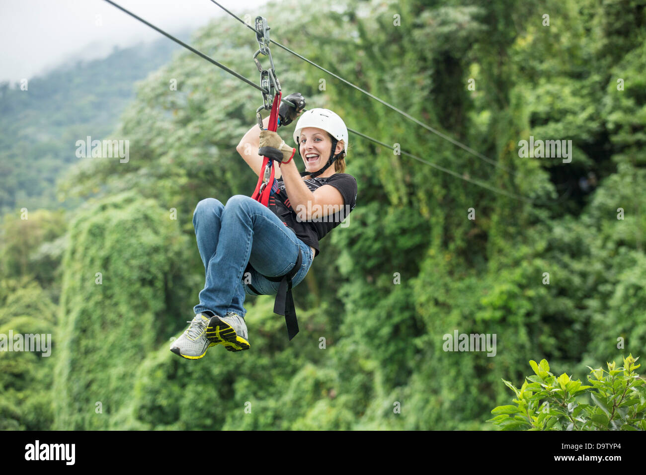 Woman riding a zip line in a forest, Costa Rica Stock Photo - Alamy