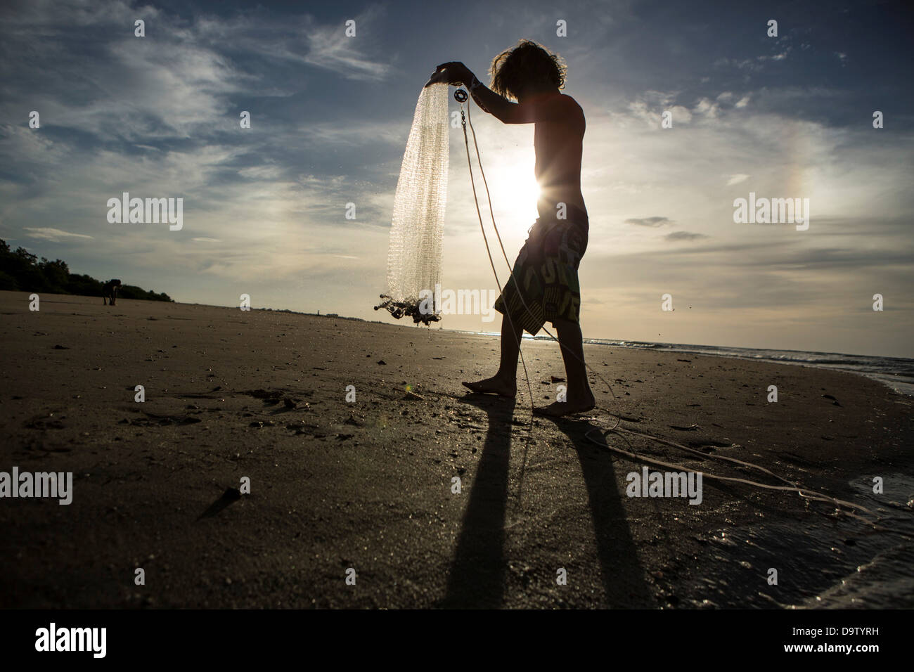 Young boy holding a net to catch bait fish on the beach, Costa Rica ...