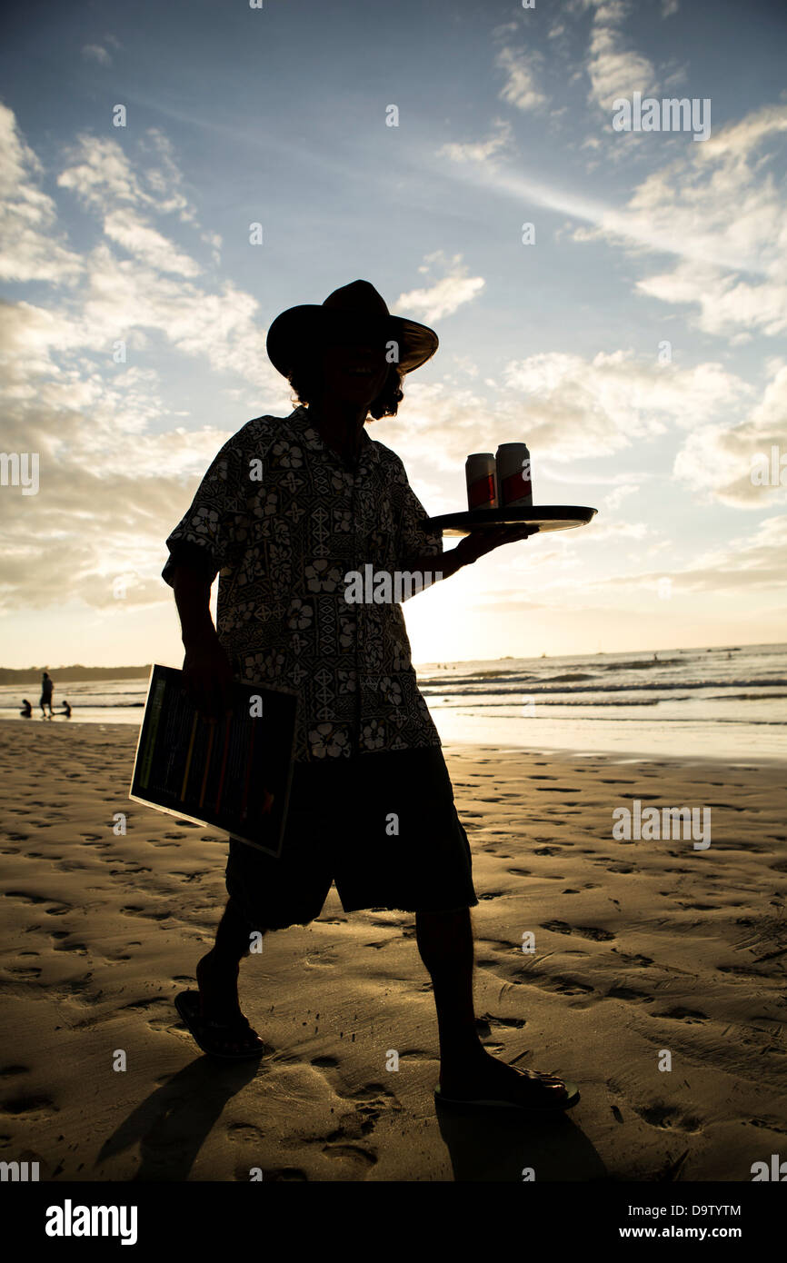 Waiter delivering a tray of drinks to patrons on the beach, Costa Rica ...