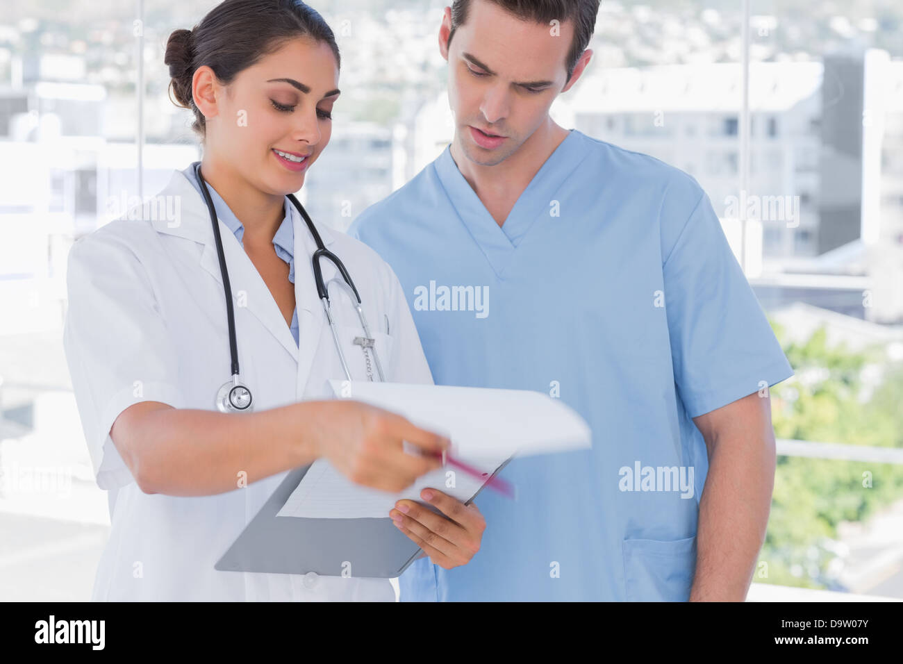 Doctor and surgeon going over notes on clipboard Stock Photo - Alamy