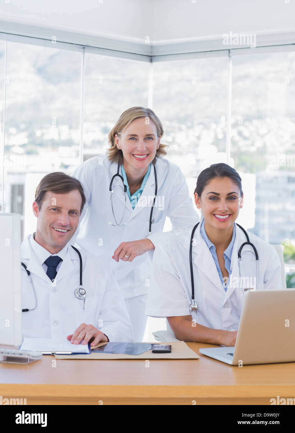 Smiling medical staff working on a laptop and a computer Stock Photo ...